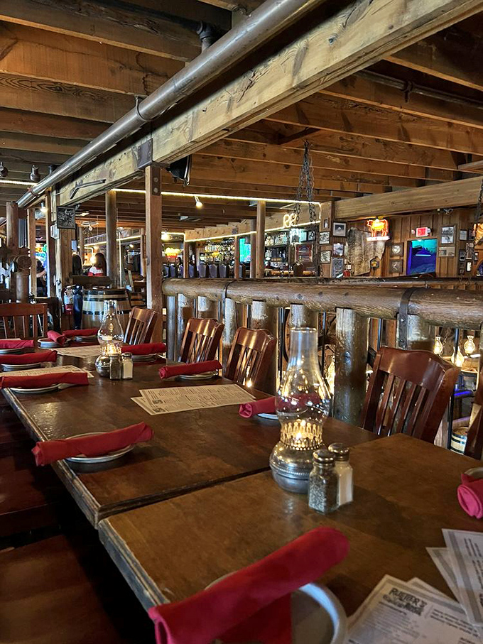 Rustic elegance defines the dining area, where oil lanterns cast a warm glow over wooden tables set with red napkins and Western charm.