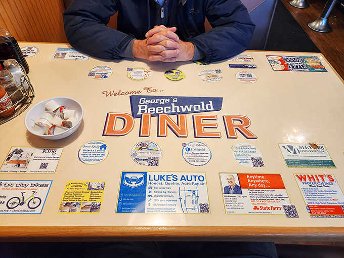 The tabletop tells stories of local businesses under clear plastic &ndash; a community bulletin board that happens to hold your breakfast while connecting you to Columbus.