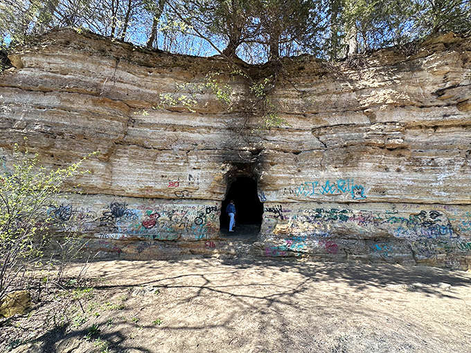 Nature's graffiti gallery &ndash; where limestone walls and human expression create an unlikely partnership at the entrance to this mysterious cave.