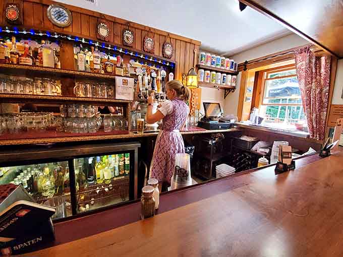 The bar area exudes old-world charm with its wooden shelves lined with steins and authentic Bavarian decorative touches throughout.