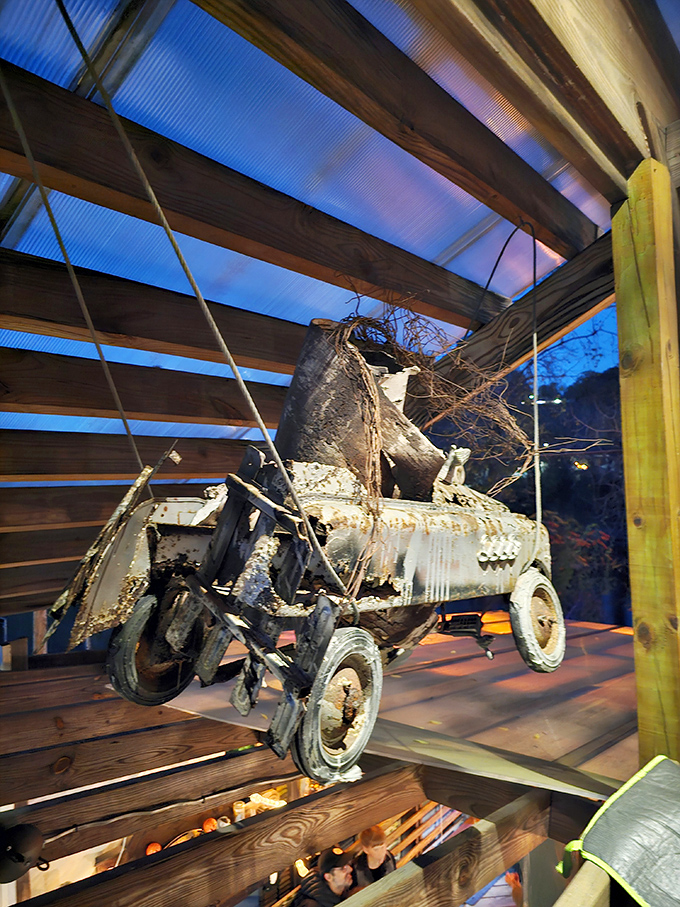 This rusty pedal car dangles from the rafters like a childhood memory suspended in time – nostalgia with a side of tetanus.