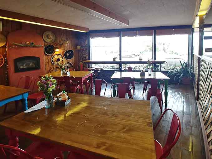 Bright orange booth seating and eclectic wall art create cozy corners perfect for settling in with friends and good food.
