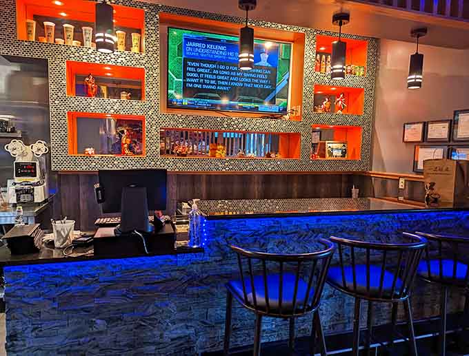 The bar area features eye-catching blue LED lighting and displays that add modern flair to this contemporary Japanese eatery.