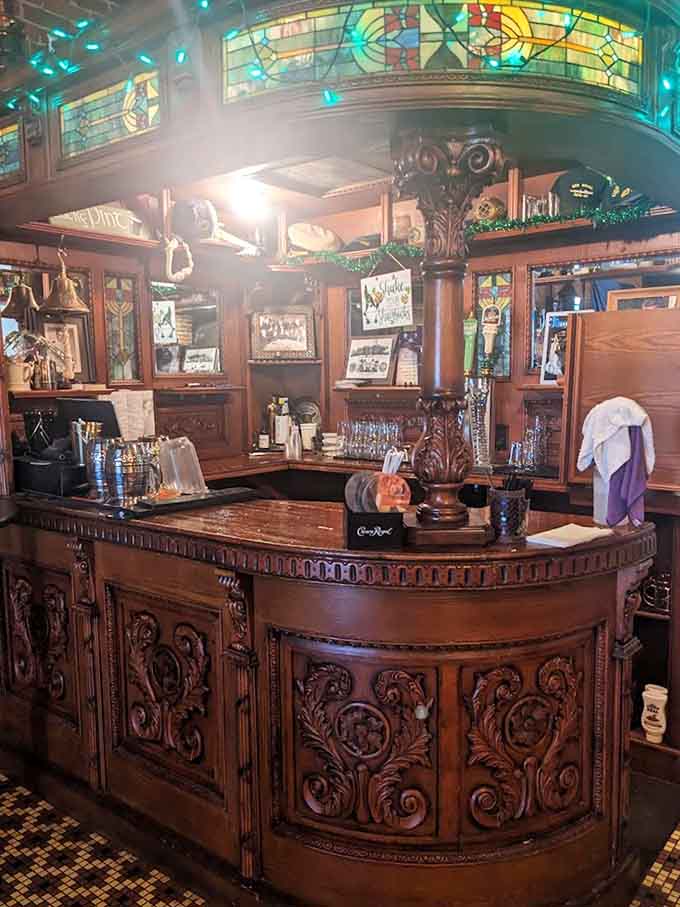 The ornate carved wood and stained glass behind the bar create an atmosphere that feels imported directly from a Dublin pub.