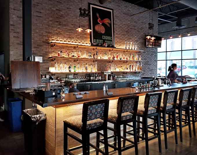 The backlit bar displays enough spirits to make any cocktail enthusiast weak in the knees, all tended by bartenders who know their craft.