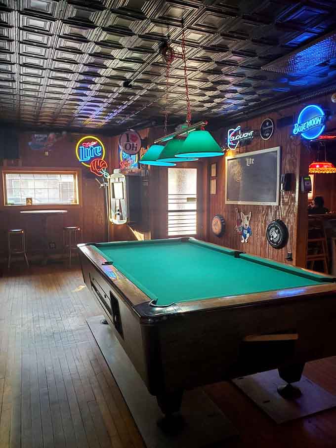 The pool table beckons under vintage beer signs, where friendly competition pairs perfectly with cold drinks.