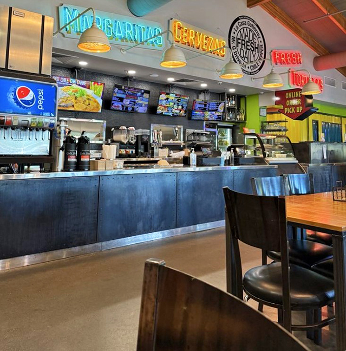 The ordering counter where taco dreams begin, complete with neon signs promising "Margaritas" and "Cervezas" – the universal language of good times.