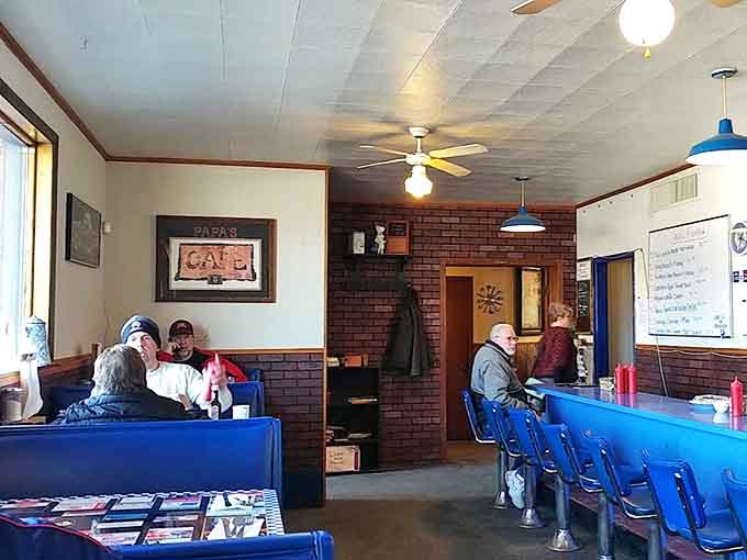 The heart of Papa's Cafe &ndash; where regulars gather at blue booths beneath ceiling fans for coffee and conversation.