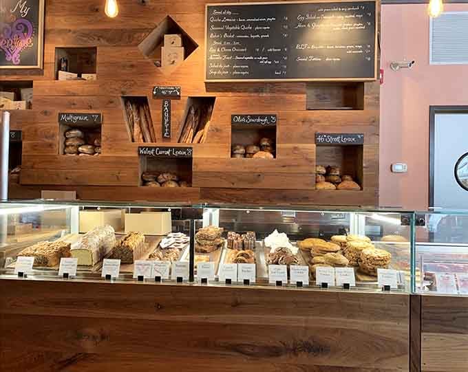 Wooden display shelves showcase fresh-baked bread like edible artwork, making choosing just one item nearly impossible for hungry visitors.