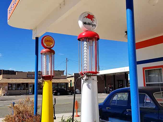 Restored visible gas pumps stand like colorful sentries, their glass globes and period graphics representing an era when even utilitarian objects had serious style.