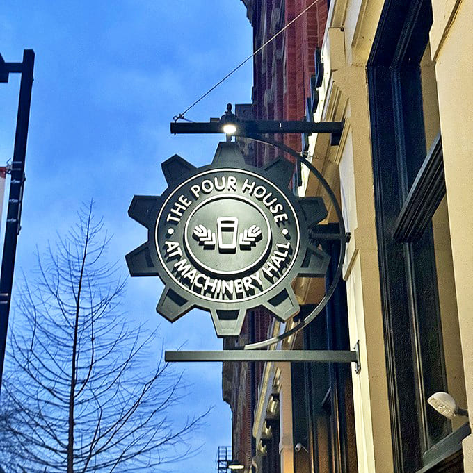 The Pour House's industrial-inspired sign glows against the twilight sky, a beacon for hungry travelers and locals alike.