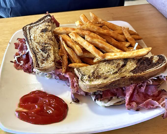 The Reuben sandwich &ndash; or "Bird That Didn't Cross The Curb" &ndash; showcases marble rye bread, generous pastrami, and a side of perfectly crisp fries.