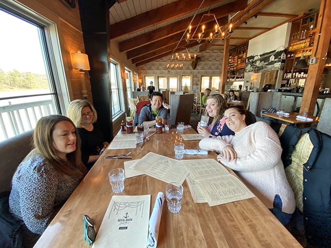 Happy diners enjoying their meals with river views is exactly the vibe you want, where good food and good company create perfect moments together.