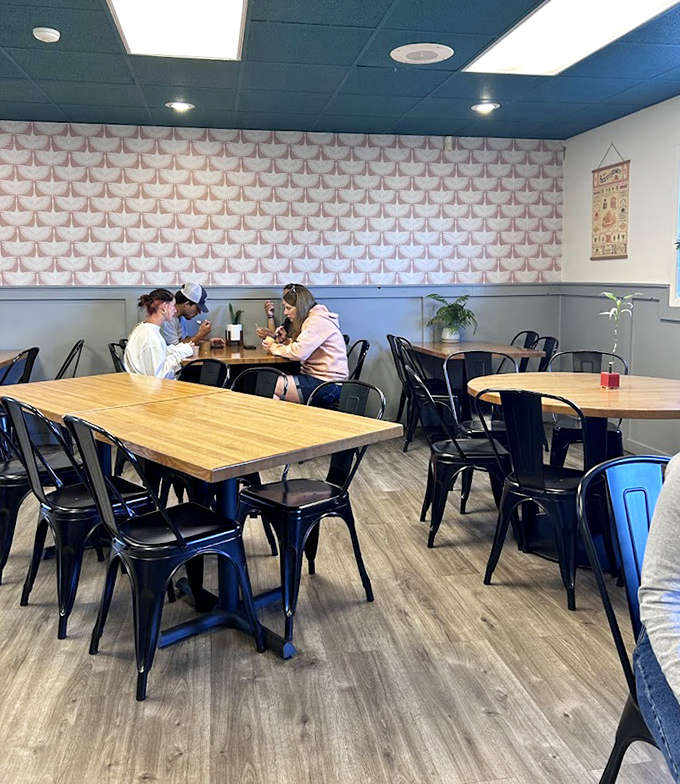 The dining area's thoughtful design creates a space where conversations flow as easily as the coffee &ndash; note the subtle geometric wall pattern adding visual interest.