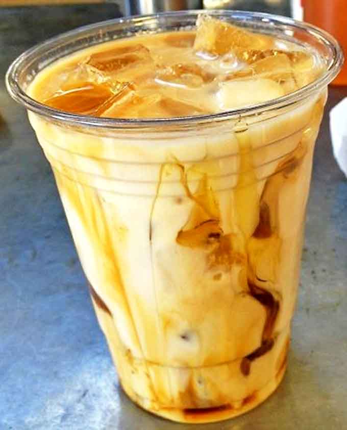Caramel cascades through iced coffee like a sweet waterfall, creating a marbled masterpiece too beautiful to stir &ndash; almost.