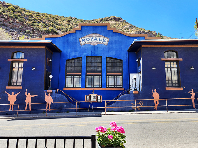 The vibrant blue Bisbee Royale building stands out against the desert landscape, its artistic silhouettes hinting at the cultural experiences within.