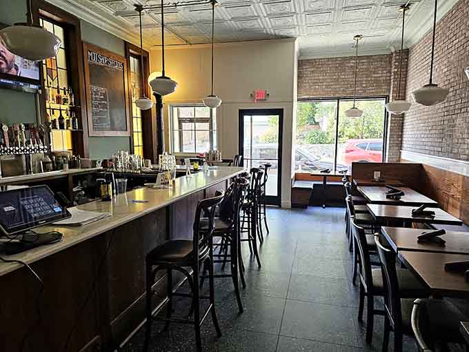 The bar area with its tin ceiling and craft beer selection offers the perfect perch for solo diners or couples seeking casual sophistication.