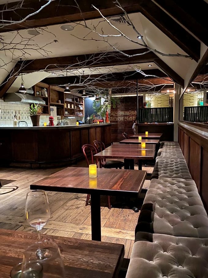 Tufted banquettes, wooden tables, and intimate lighting create a space where time slows down and conversations flow as smoothly as the wine.