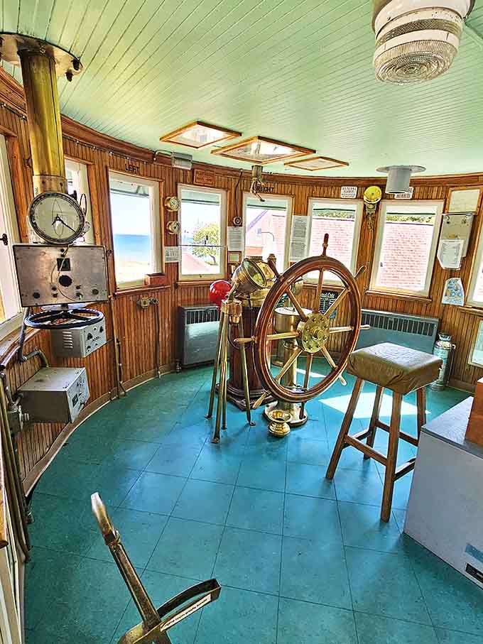 This polished wooden wheel once guided massive vessels through treacherous waters, its smooth surface worn by the hands of captains who trusted lighthouses to lead them safely home.