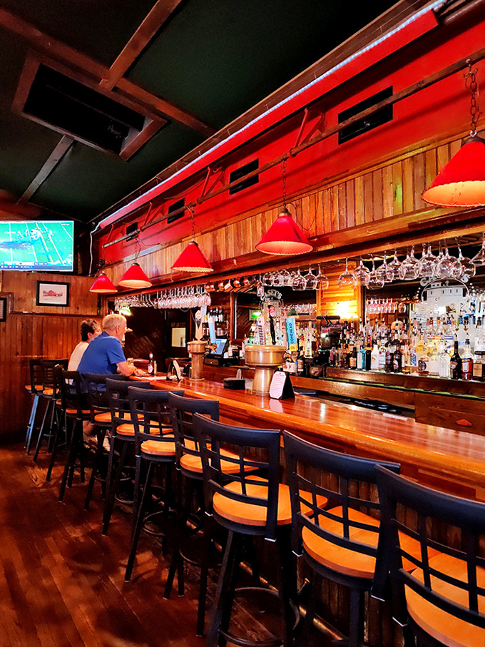 High-top tables and warm lighting create intimate dining spaces where conversations flow as easily as the drinks from the well-stocked bar.