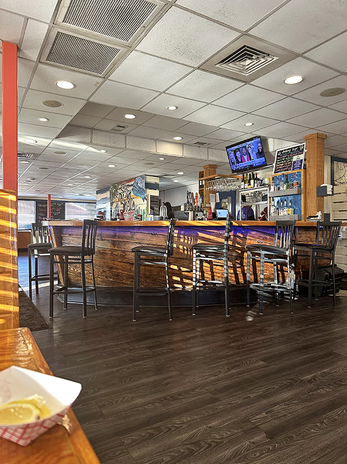 The bar area buzzes with energy as patrons enjoy cold drinks and hot seafood in an atmosphere that's both lively and laid-back.