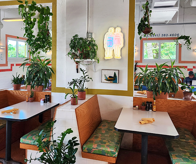 Cozy booths with patterned upholstery invite lingering conversations – while plants cascade from above, creating nature's own privacy screens.