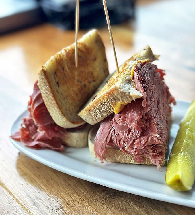 A close-up that reveals the architectural wonder of properly stacked corned beef. Each slice thin, tender, and part of a delicious tower that requires strategic eating.