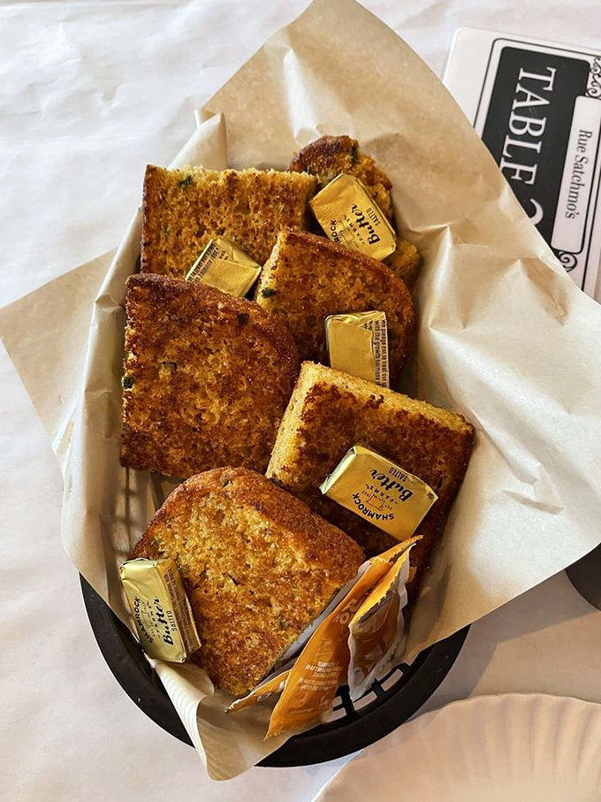 Golden cornbread squares with butter pats melting between them &ndash; the perfect vehicle for sopping up every last bit of sauce.