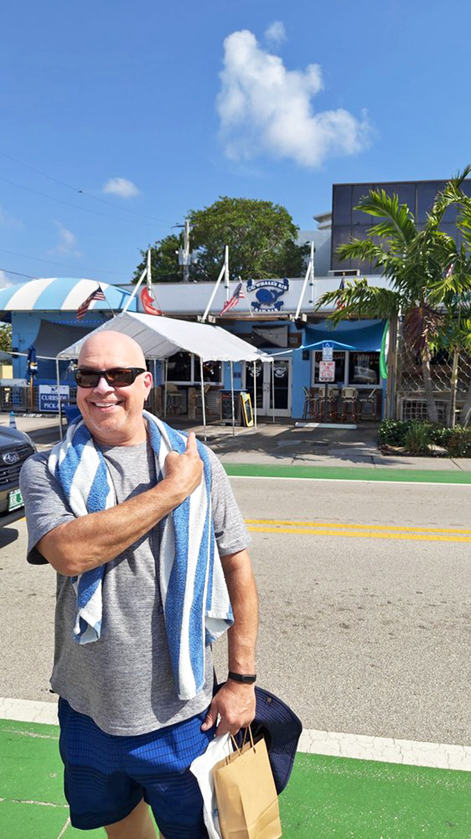 A satisfied customer points proudly toward Whale&rsquo;s Rib &ndash; that post-stone-crab glow is unmistakable and highly contagious.