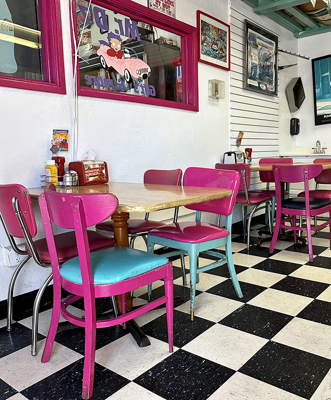 Hot pink chairs pop against turquoise accents, creating a color palette that screams "1950s" in the most delightful way possible.