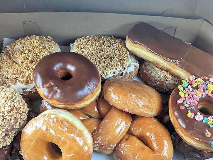This box of mixed donuts represents hope, possibility, and the inevitable sugar crash &ndash; a cardboard container of temporary joy worth every calorie.