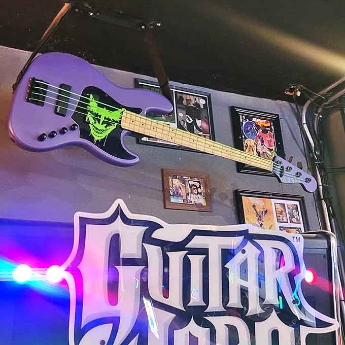 A purple bass with green skull graphic watches over gamers, suggesting this Viking hall occasionally rocks with more than just arcade sounds.
