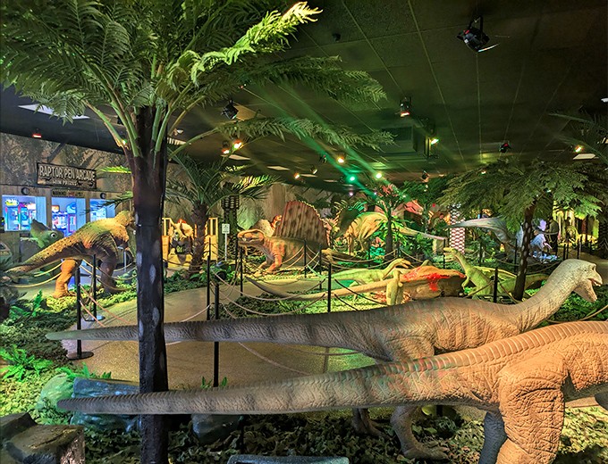 The main exhibition hall's dramatic lighting transforms static displays into a dynamic prehistoric world frozen in time.