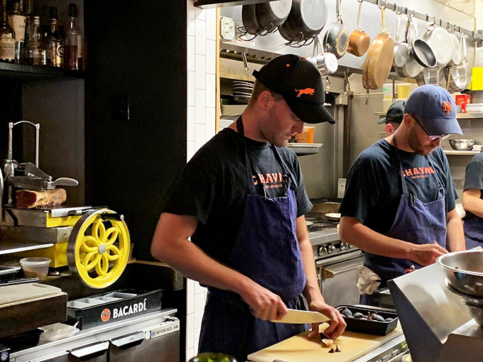 In Chaval's kitchen, focused chefs transform simple ingredients into extraordinary dishes, their concentration a testament to their craft.