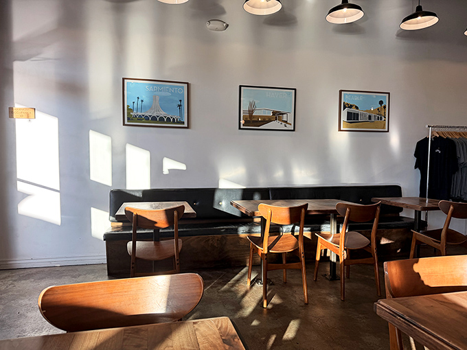 Sunlight streams through windows, illuminating mid-century chairs and minimalist wall art in this thoughtfully designed dining space.