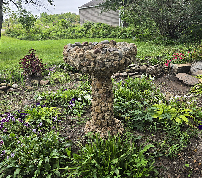 This birdbath sculpture shows that even functional garden pieces deserve artistic treatment, offering local birds a drink while giving visitors something interesting to photograph between the castle shots.