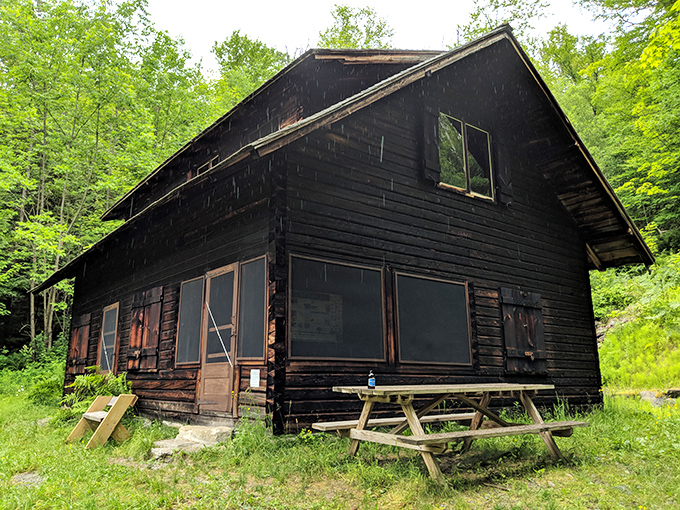 This rustic cabin stands as a silent witness to Vermont's changing seasons, nestled among trees that have seen centuries pass.
