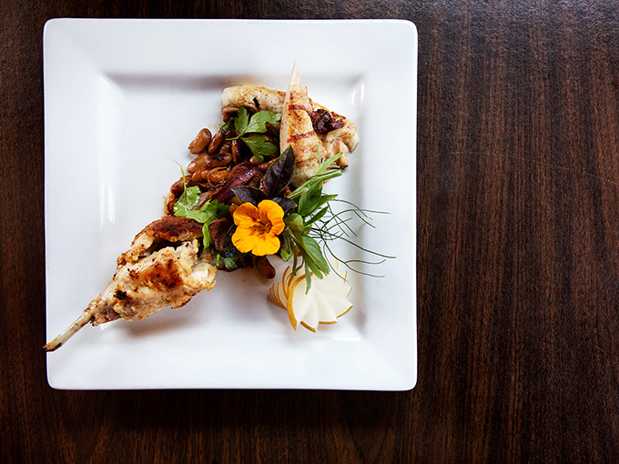 Heritage cooking meets modern technique in this succulent rack presentation – rustic beans and bright vegetables create perfect harmony on the plate.