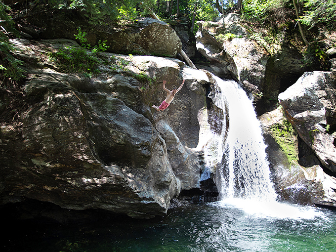 Sunlit cliffs and emerald water invite one brave swimmer to take the plunge at beautiful Bingham Falls.