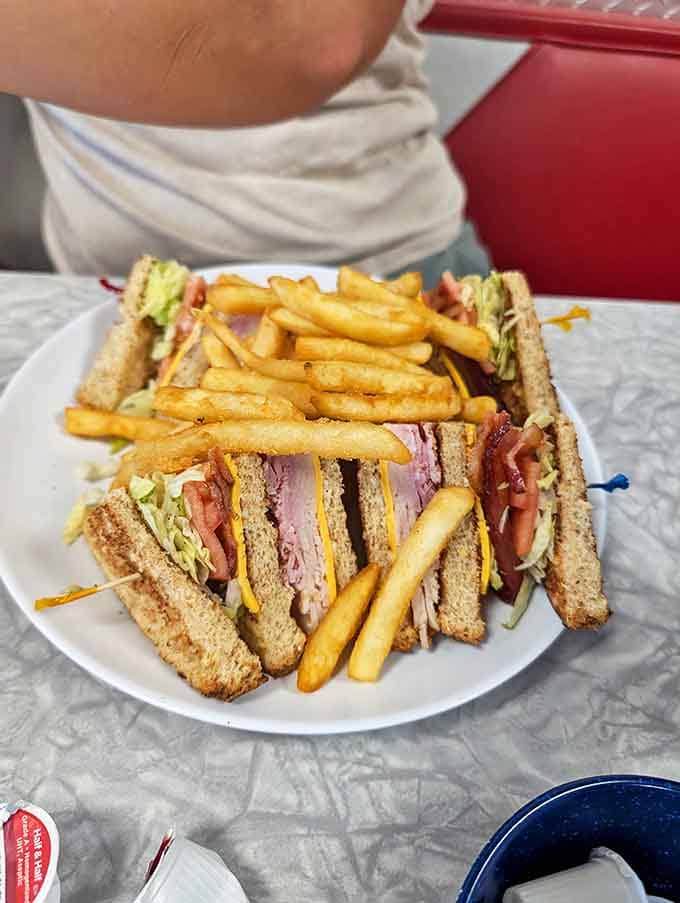 Club sandwich stacked so high it needs its own zip code, with fries that deserve their own fan club.