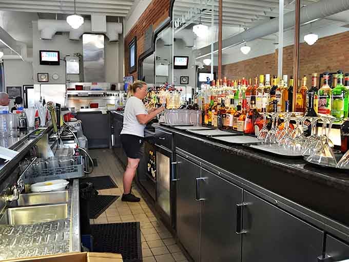 Behind this bar, bottles stand like soldiers ready for duty while bartenders craft drinks with the precision of artists.