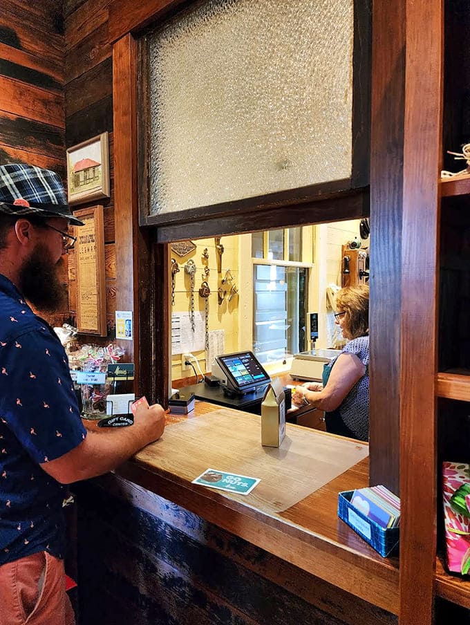 The transaction window preserves the shop's historic charm, where friendly staff continue a tradition of exceptional service and sweet expertise.