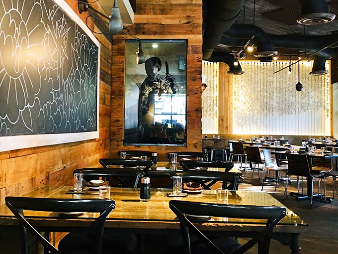 Rustic wood walls embrace modern black tables, while artistic touches remind you this isn't your average sushi joint.
