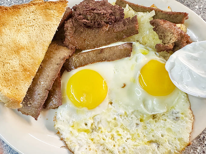The classic steak and eggs breakfast delivers protein-packed satisfaction with perfectly cooked sunny-side-up eggs and buttery toast.