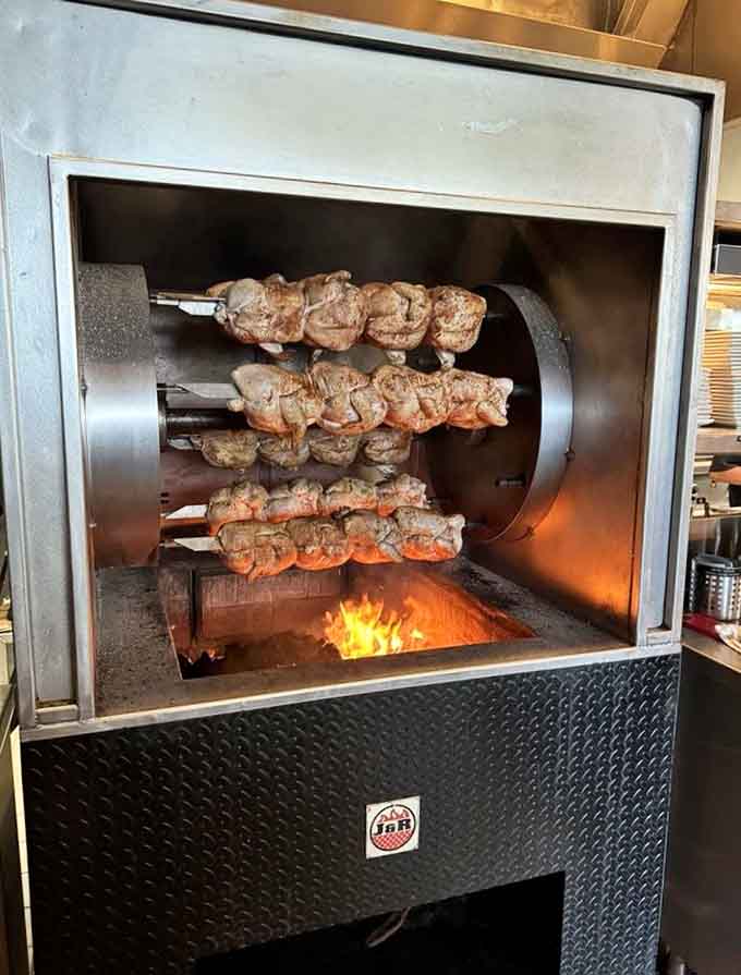 The rotisserie grill works its magic on skewered meats, adding smoky flavor and visual drama to the dining experience.