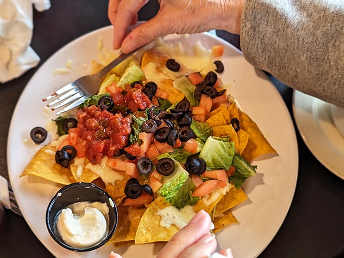 These loaded nachos aren't just an appetizer &ndash; they're a commitment. Crispy chips buried under an avalanche of toppings that require strategic eating techniques.