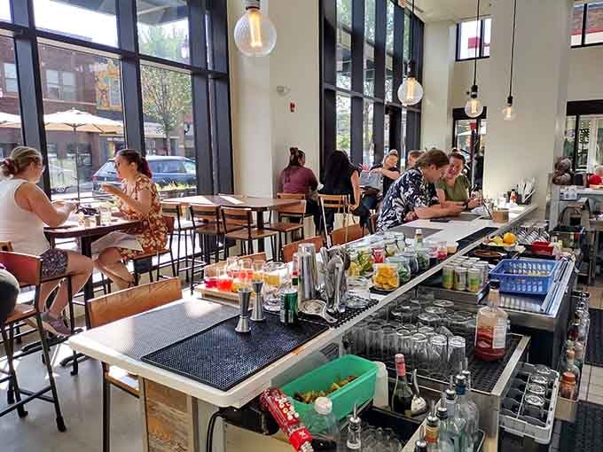 Diners enjoy their meals in the bright, airy space where floor-to-ceiling windows prove that people-watching pairs perfectly with pork belly.