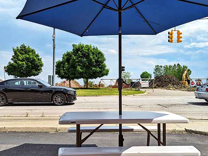 Simple white tables under blue umbrellas &ndash; where strangers become friends over shared condiments and car compliments.