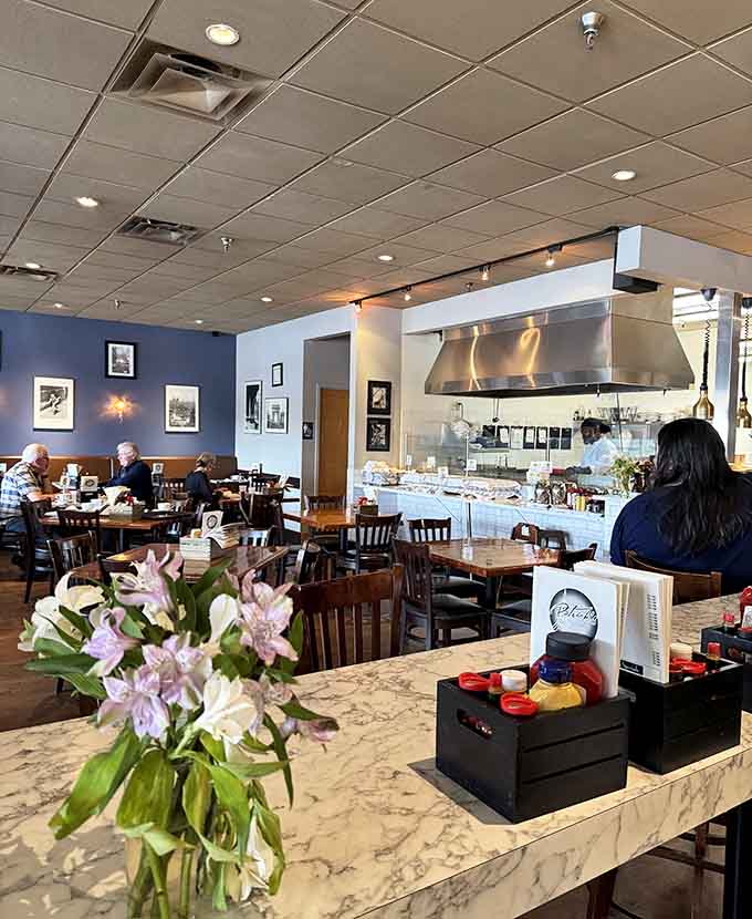 Another angle reveals the open kitchen where magic happens, letting diners watch their breakfast dreams become delicious reality.