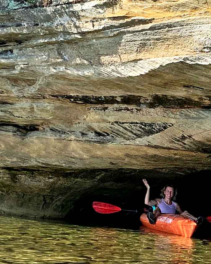 Adventurous paddlers explore hidden sea caves along the shoreline route to Turnip Rock, where cool shadows offer respite on hot summer days.